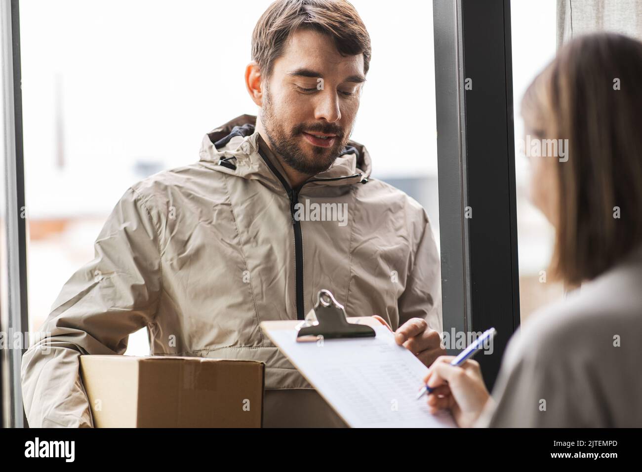 delivery man with parcel box and customer at home Stock Photo - Alamy