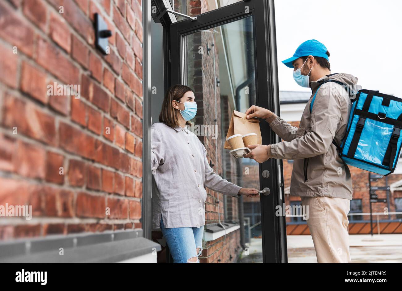 food delivery man in mask giving order to customer Stock Photo - Alamy
