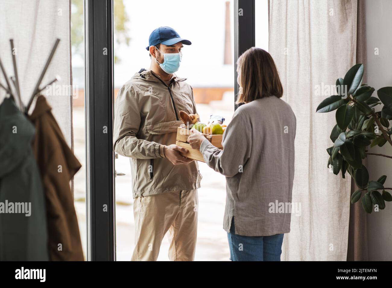food delivery man in mask giving order to customer Stock Photo - Alamy