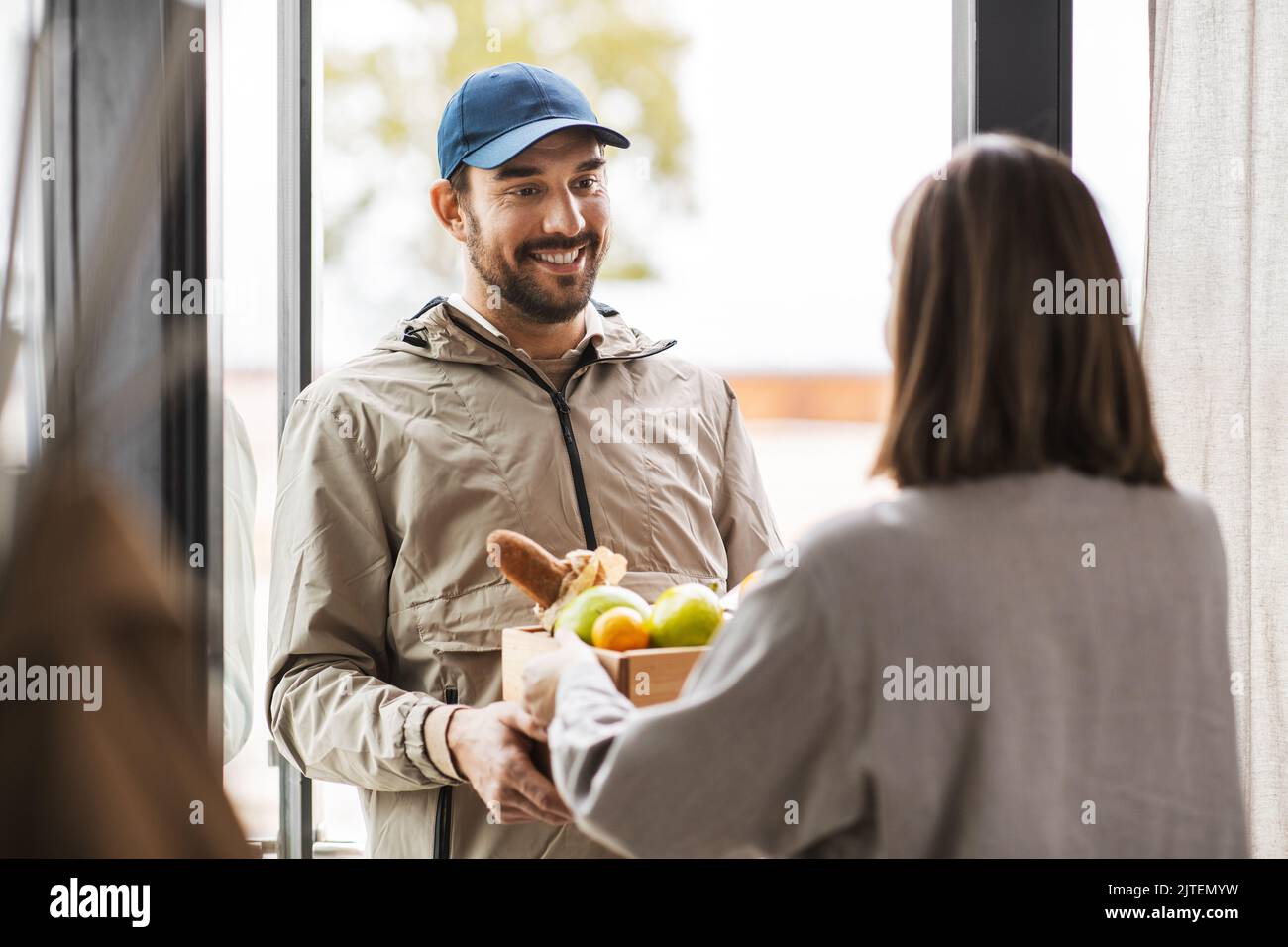 food delivery man giving order to female customer Stock Photo - Alamy
