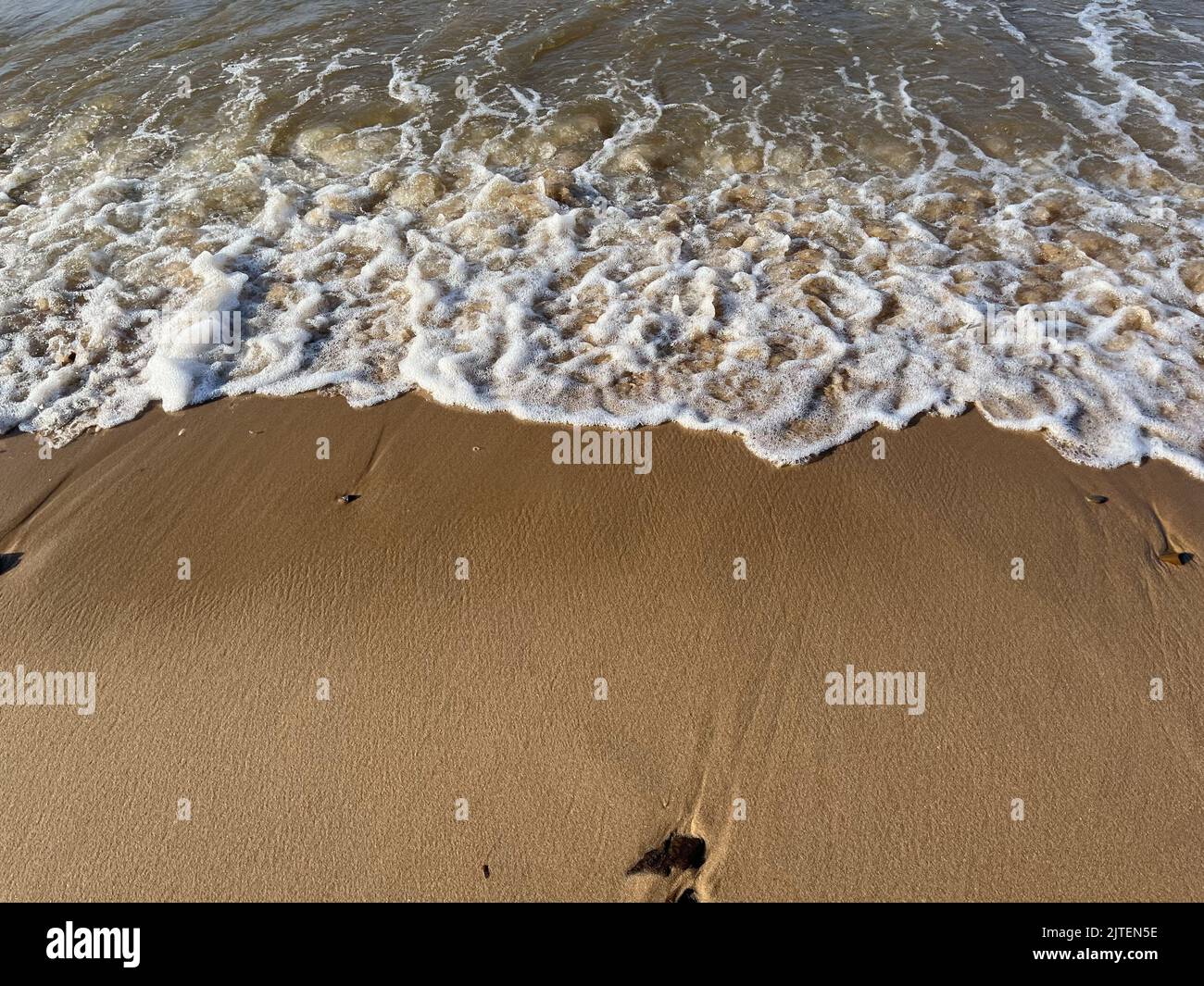 The sea water reaching the wet sand Stock Photo - Alamy