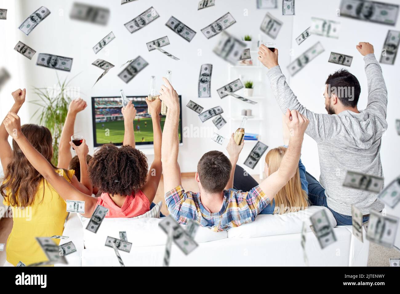 happy football fans watching tv over money rain Stock Photo - Alamy