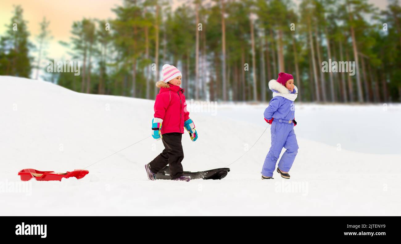 happy little girls with sleds walking in winter Stock Photo - Alamy