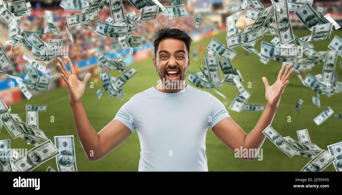 happy man with over money rain on football field Stock Photo - Alamy