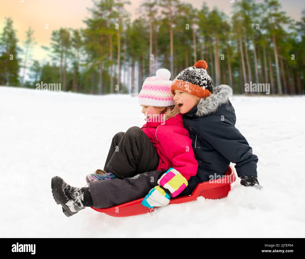little kids sliding on sled down hill in winter Stock Photo - Alamy