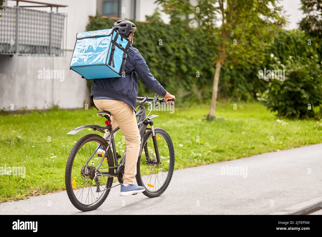 food delivery man with bag riding bicycle Stock Photo - Alamy