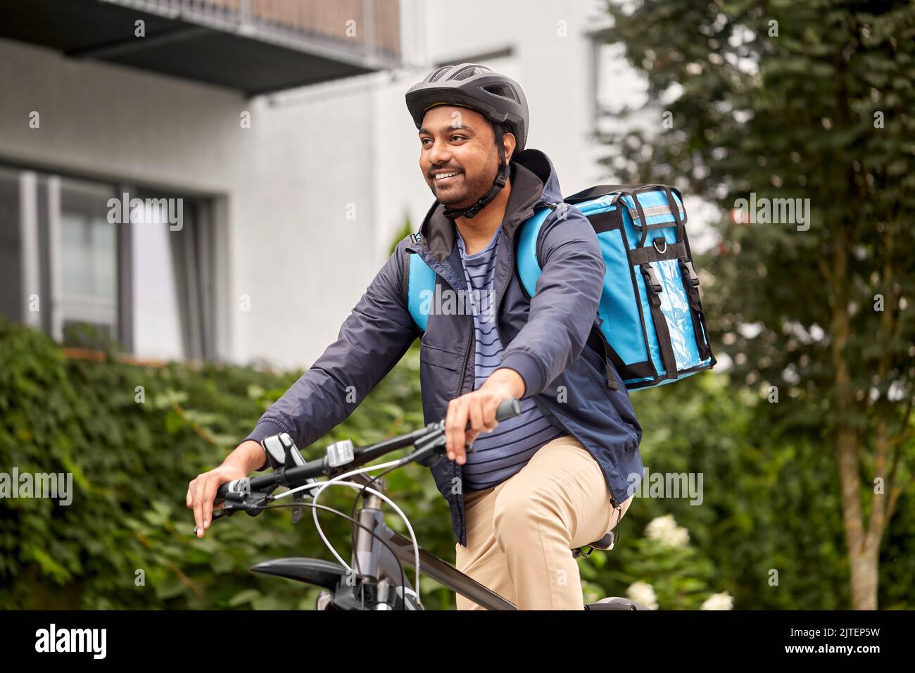 food delivery man with bag riding bicycle Stock Photo - Alamy