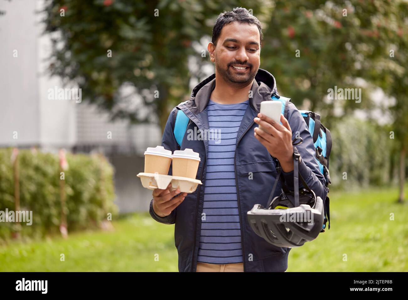 food delivery man with takeaway coffee and phone Stock Photo - Alamy