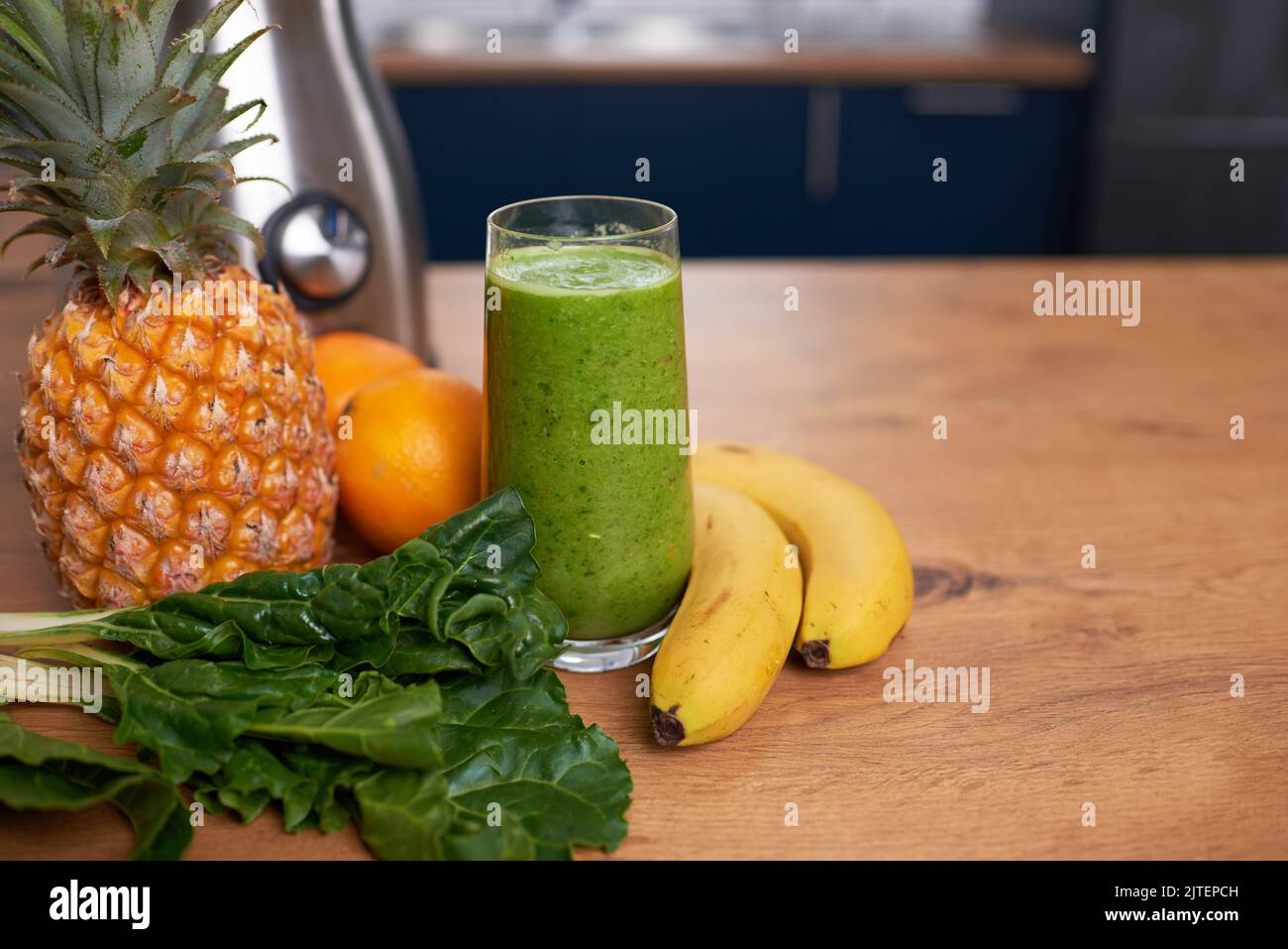 Close up still life of whole fruit and freshly made green smoothie in ...