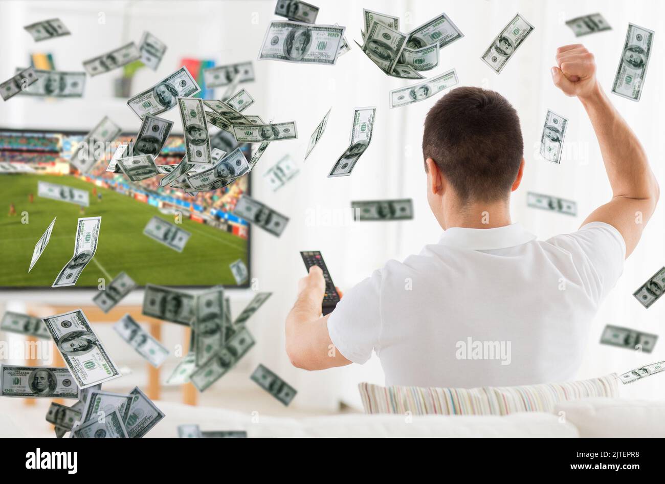 happy man watching soccer game on tv over money Stock Photo - Alamy