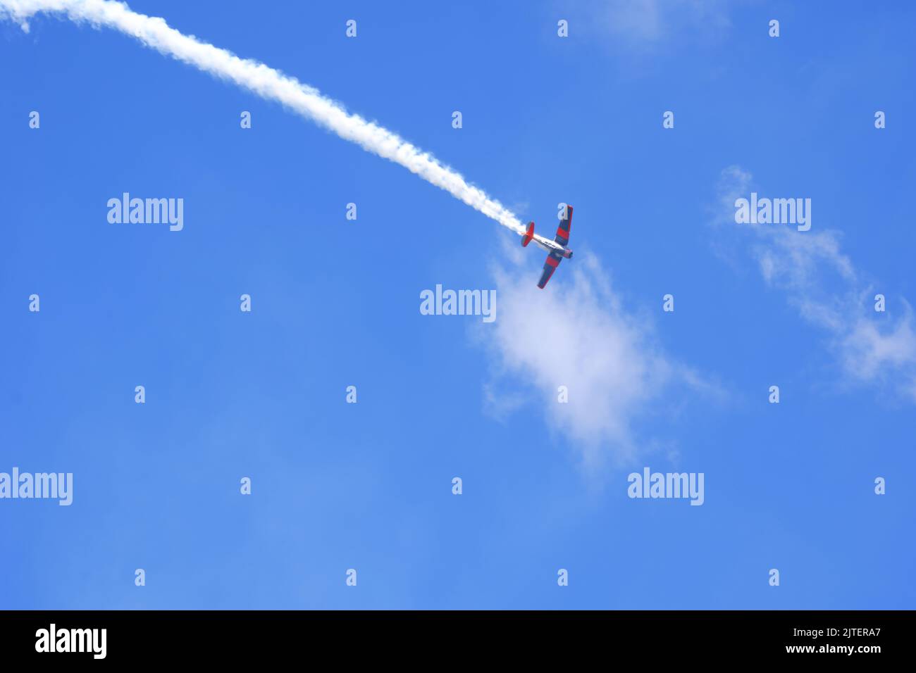 Single Engine Small Airplane Making Acrobatic Maneuvers At Cloudy Sky With Smoke On Tail Stock