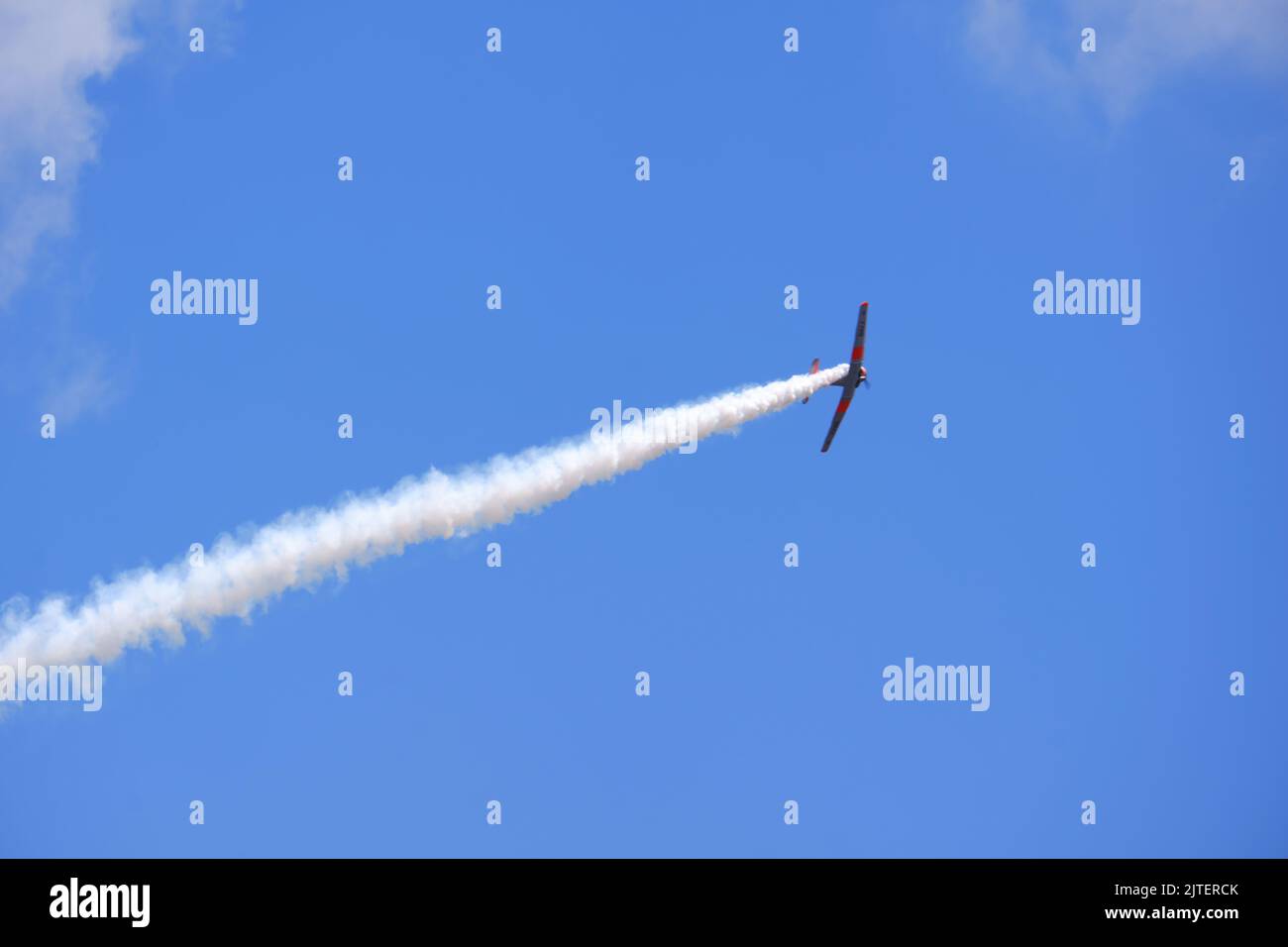 Single engine small airplane making acrobatic maneuvers at cloudy sky ...