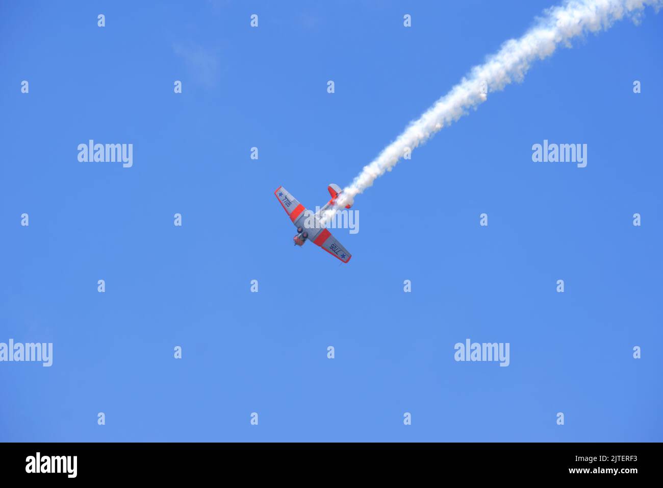 Single engine small airplane making acrobatic maneuvers at cloudy sky ...