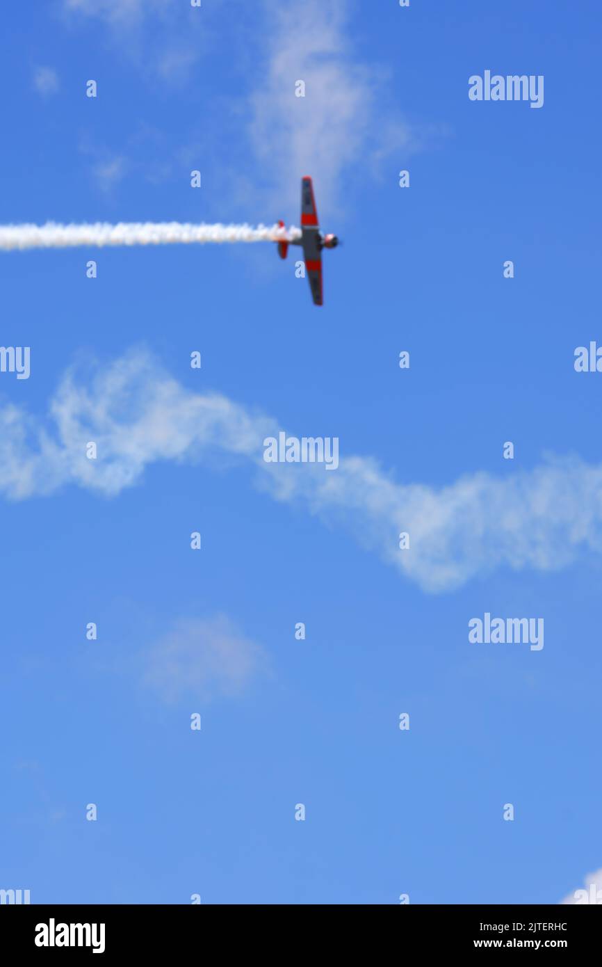 Single engine small airplane making acrobatic maneuvers at cloudy sky ...