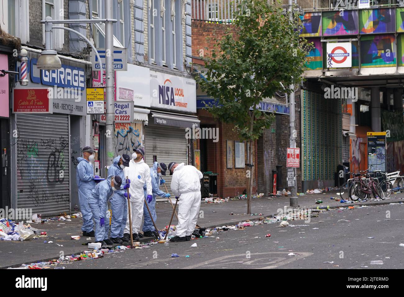 Forensics officers comb the scene in Ladbroke Grove, west London, where ...