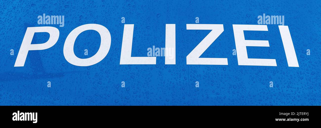 lettering of the German word of police on a wet blue police car Stock ...