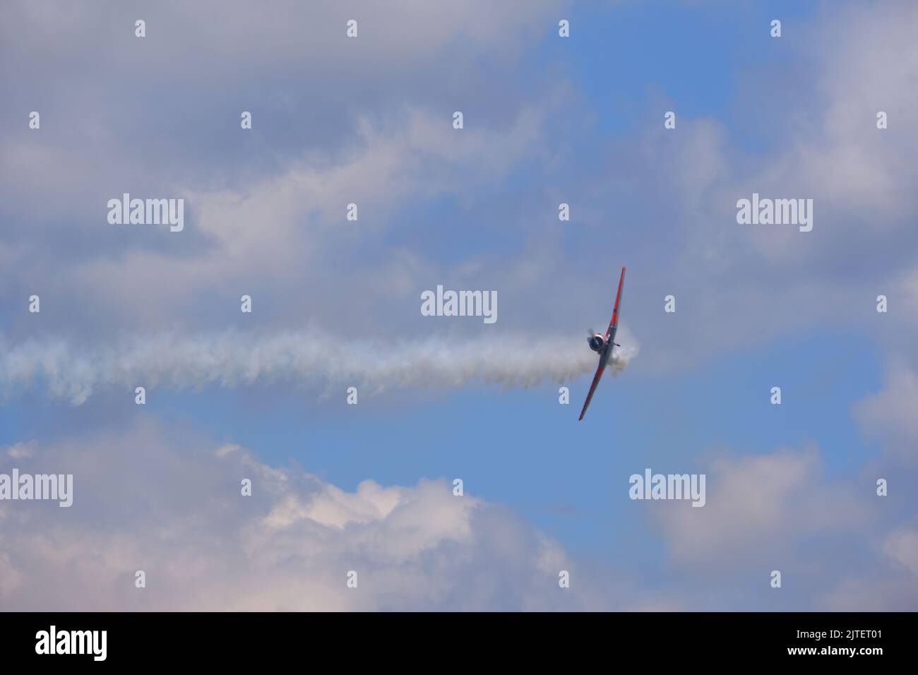 Single engine small airplane making acrobatic maneuvers at cloudy sky ...