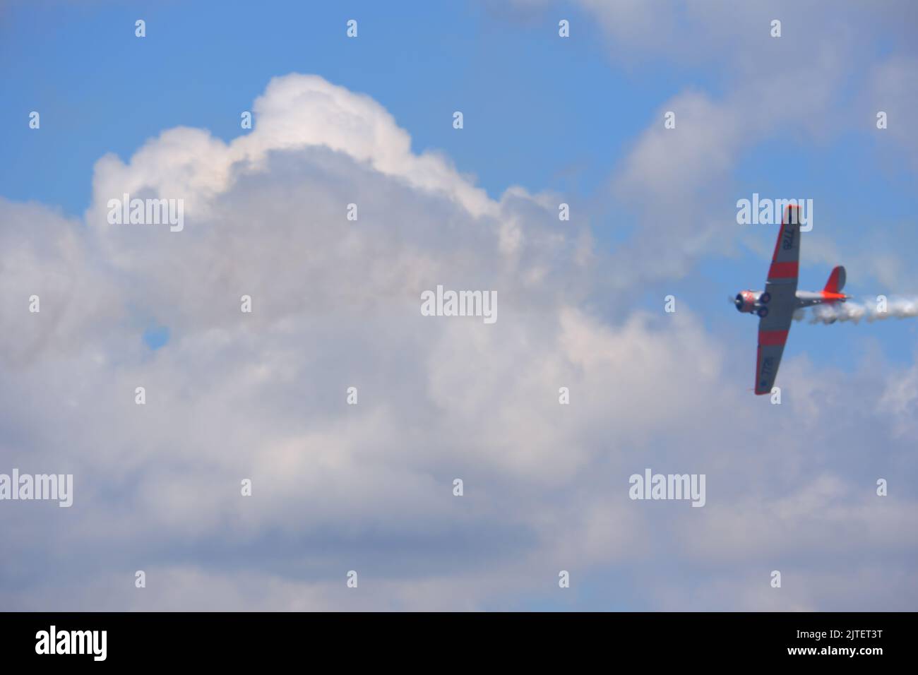 Single engine small airplane making acrobatic maneuvers at cloudy sky ...