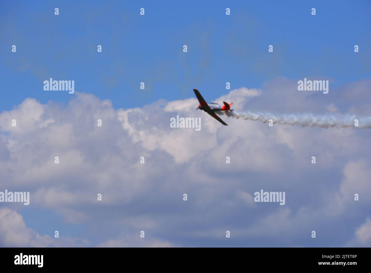 Single engine small airplane making acrobatic maneuvers at cloudy sky ...
