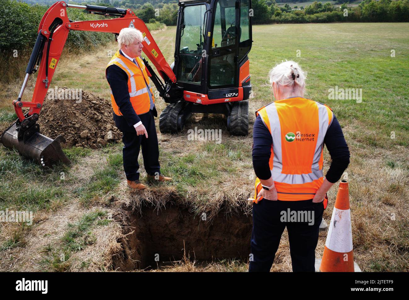 Prime Minister Boris Johnson points to a hole in the ground during a ...