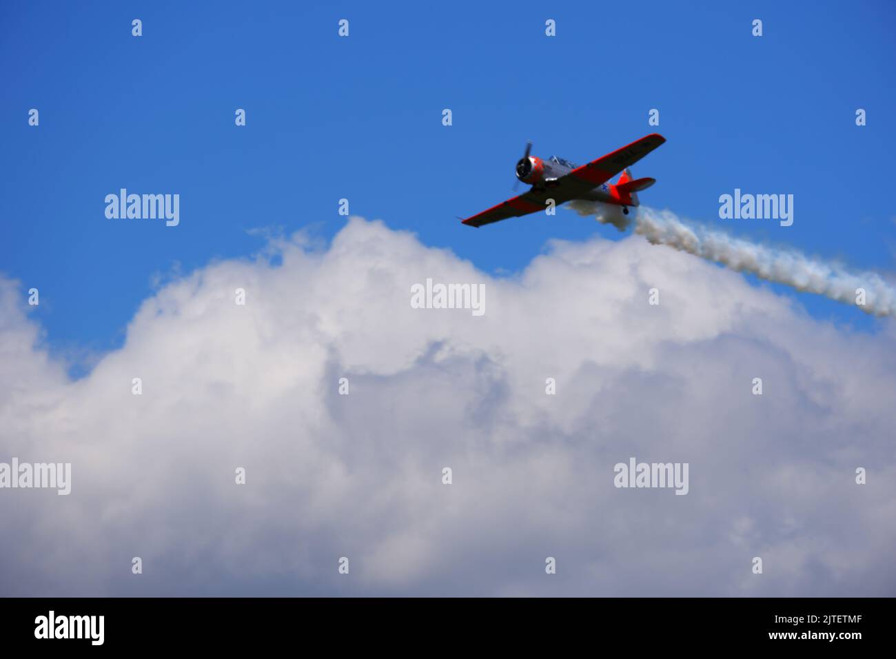Single engine small airplane making acrobatic maneuvers at cloudy sky ...