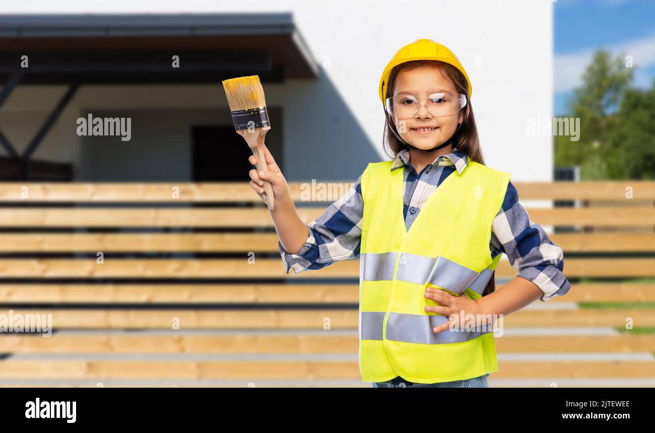 girl in helmet and safety vest with paint brush Stock Photo - Alamy