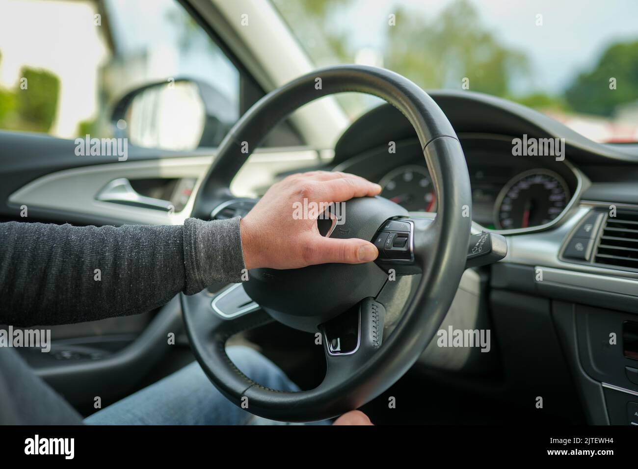A closeup of man's hand on a steering wheel of a car Stock Photo - Alamy