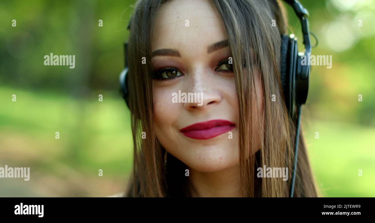 Millennial girl listening to song wearing headphones. 20 year old woman ...