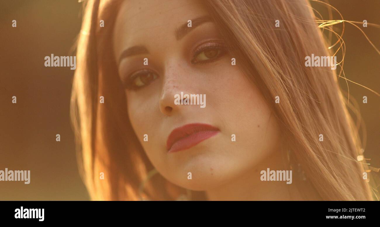 Pensive young woman during dreamlike golden hour sunset time ...