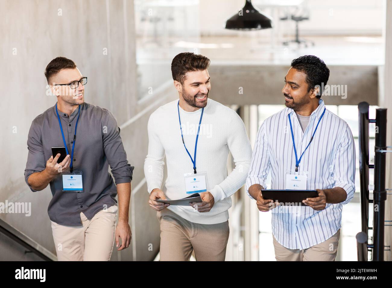 men with conference badges walking upstairs Stock Photo - Alamy
