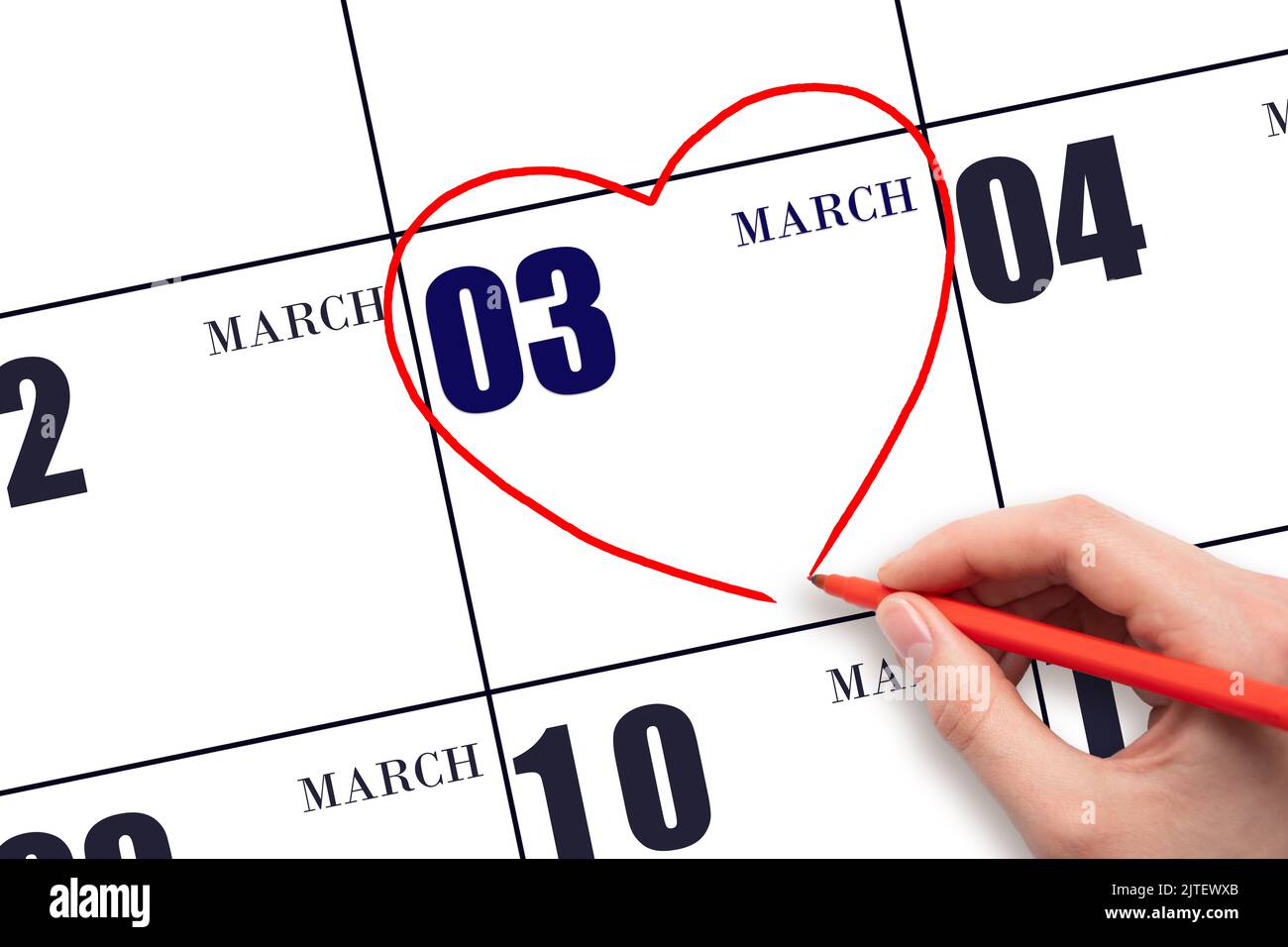 3rd day of March. A woman's hand drawing a red heart shape on the ...