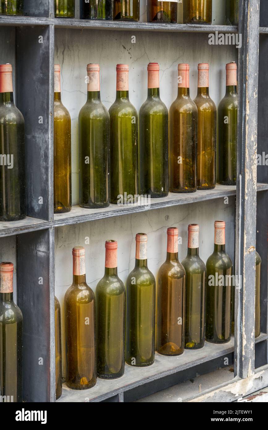 Pile of empty red wine bottles on display window outdoors Stock Photo ...