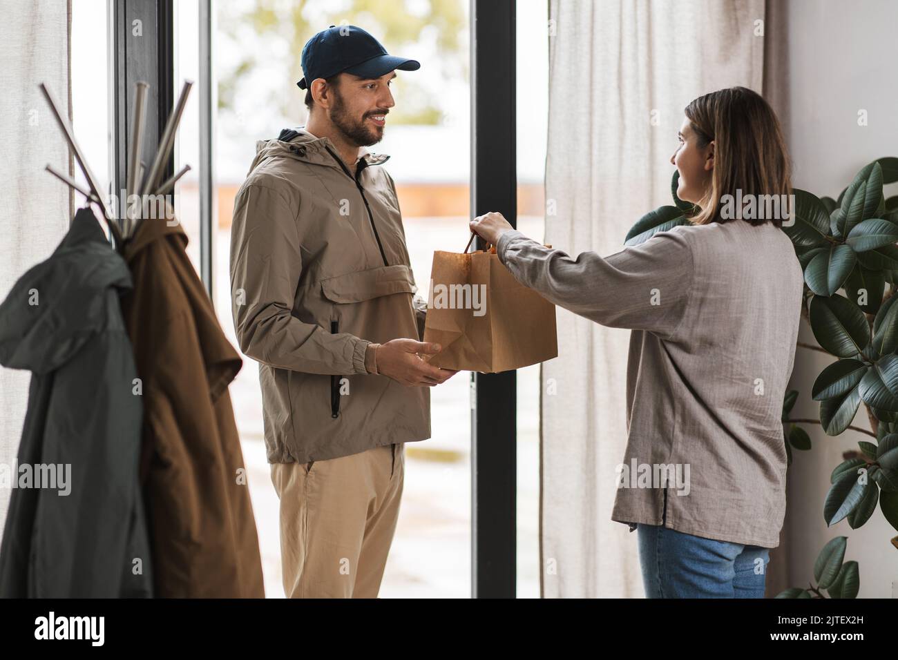 food delivery man giving order to female customer Stock Photo - Alamy