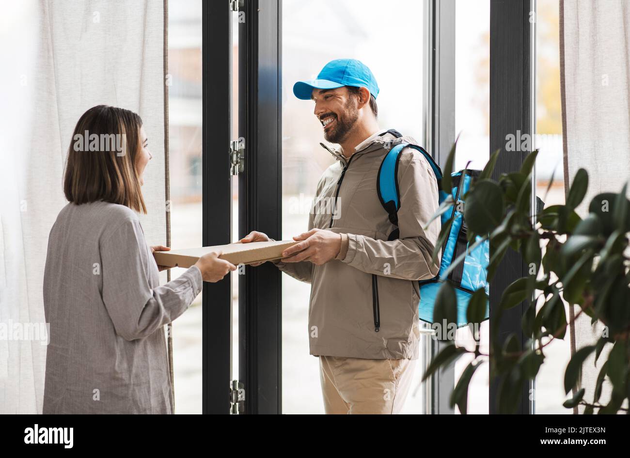 food delivery man giving order to female customer Stock Photo - Alamy