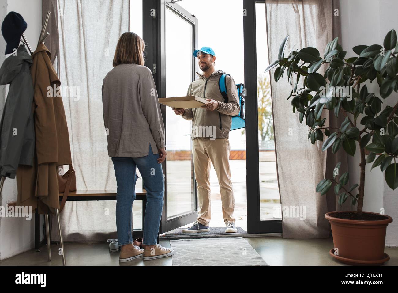 food delivery man giving order to female customer Stock Photo - Alamy