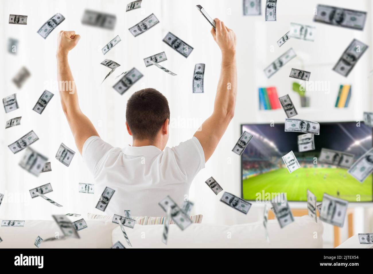 happy man watching soccer game on tv over money Stock Photo - Alamy