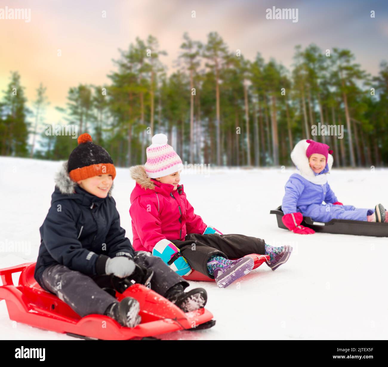 happy little kids sliding on sleds in winter Stock Photo - Alamy