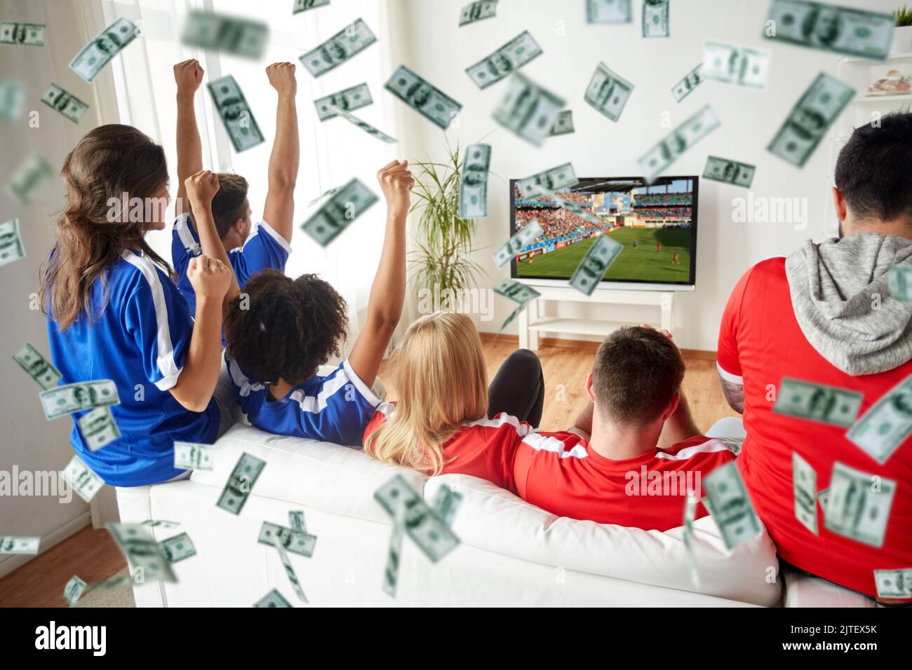 happy football fans watching tv over money rain Stock Photo - Alamy