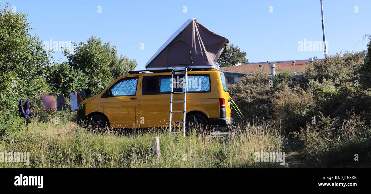 a new yellow camper van with a roof tent Stock Photo - Alamy