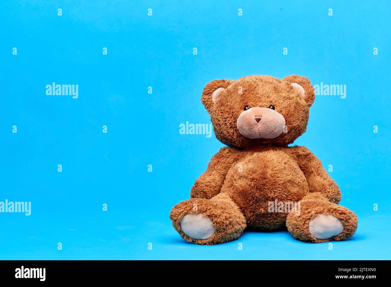 brown teddy bear toy over blue background Stock Photo - Alamy