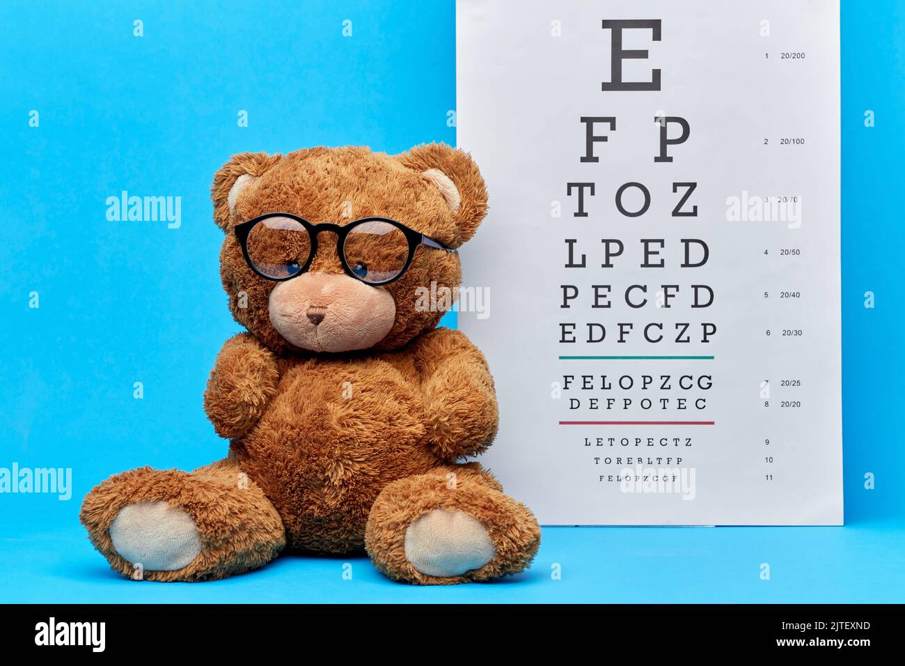teddy bear toy in glasses with eye chart on blue Stock Photo - Alamy