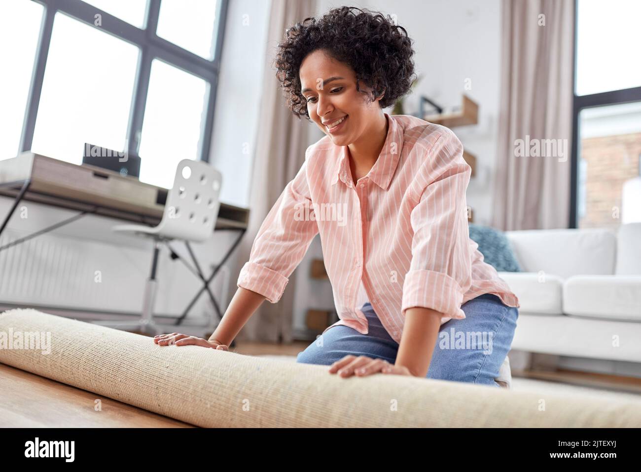 Young woman unfolding carpet hi-res stock photography and images - Alamy