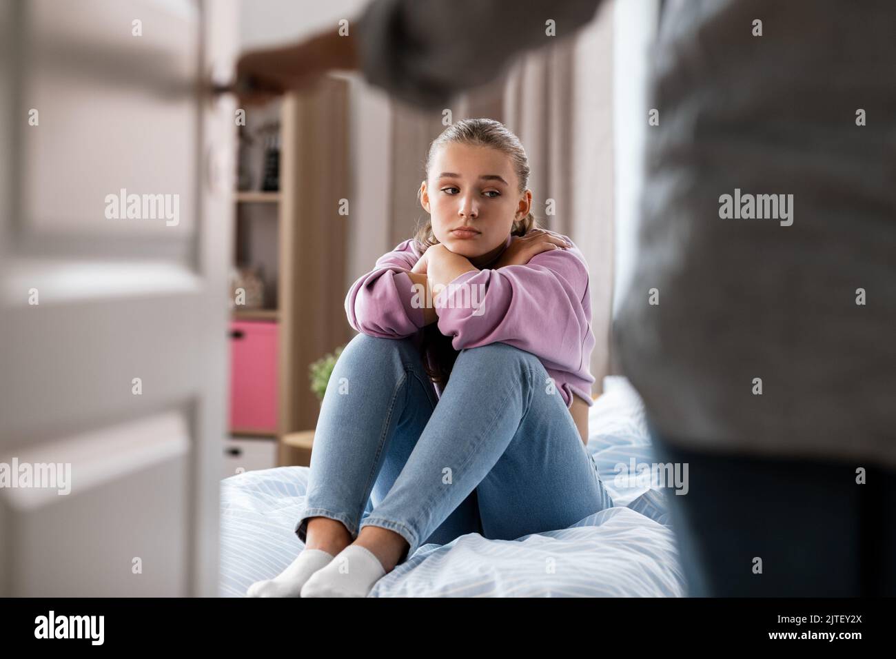 mother and sad daughter sitting on bed at home Stock Photo - Alamy