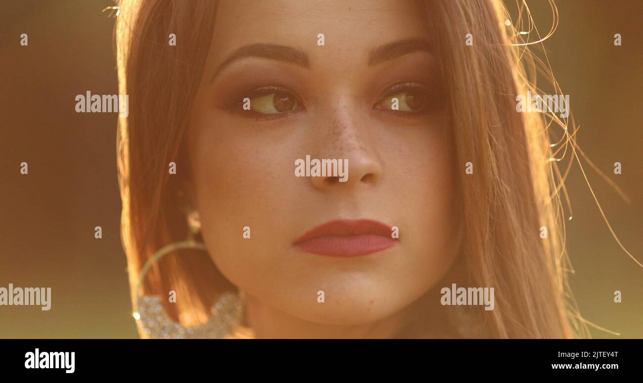 Pensive young woman during dreamlike golden hour sunset time ...