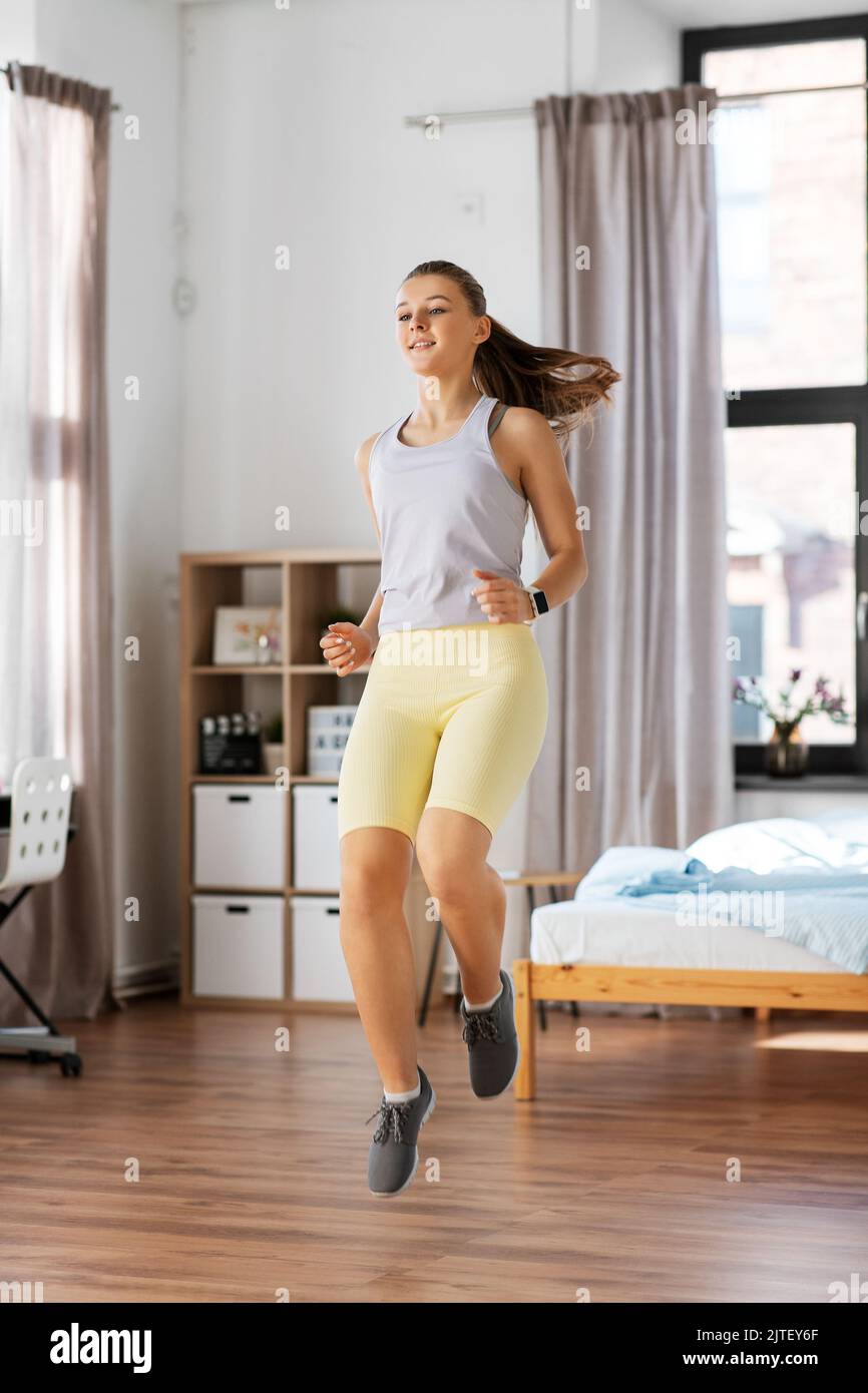 smiling teenage girl running on spot at home Stock Photo - Alamy