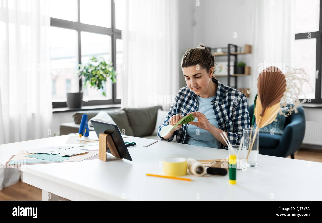 woman with tablet pc making paper craft at home Stock Photo - Alamy