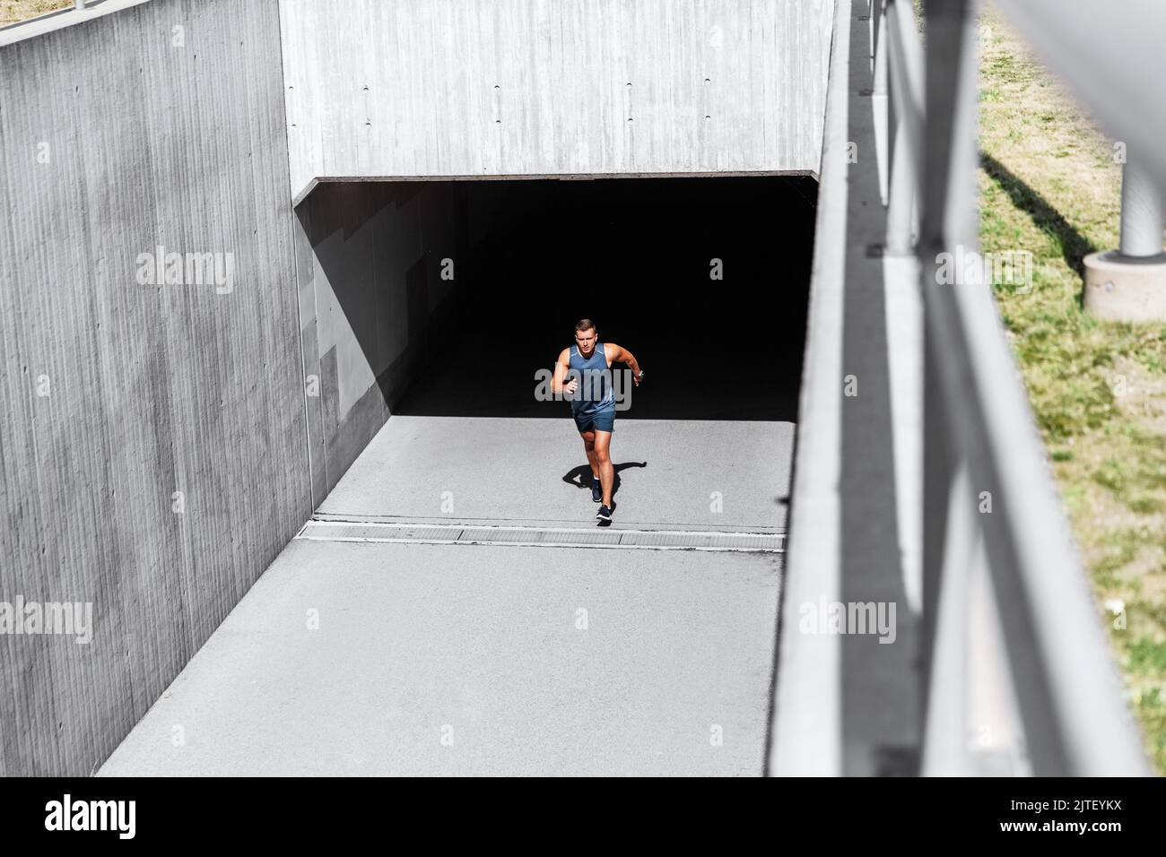 young man running out of tunnel Stock Photo - Alamy
