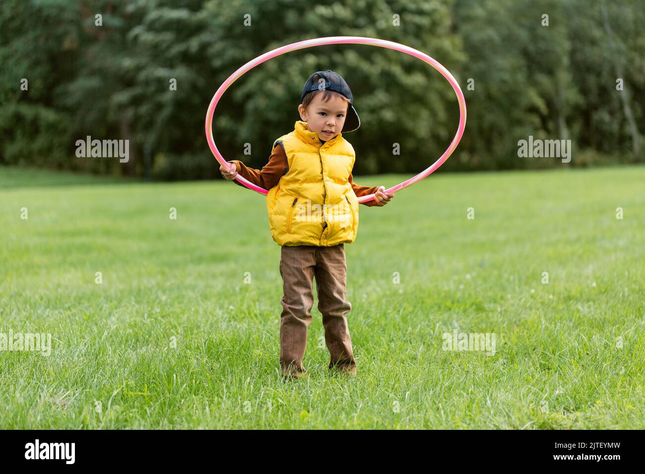 happy little boy playing with hula hoop at park Stock Photo - Alamy