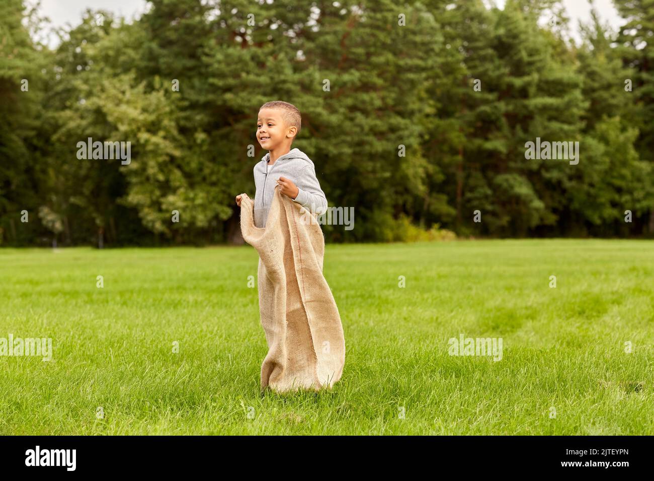 happy boy playing bag jumping game at park Stock Photo - Alamy
