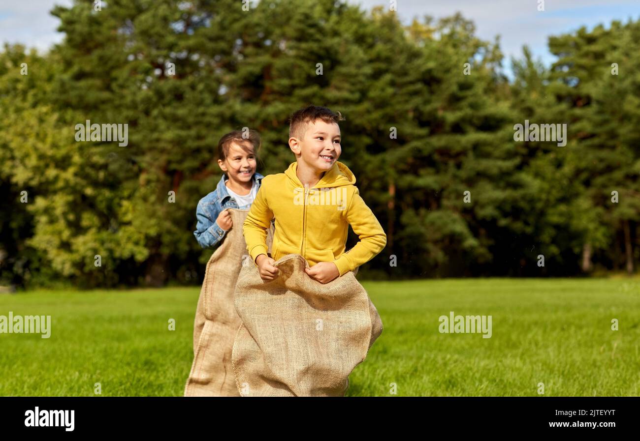 happy children playing bag jumping game at park Stock Photo - Alamy